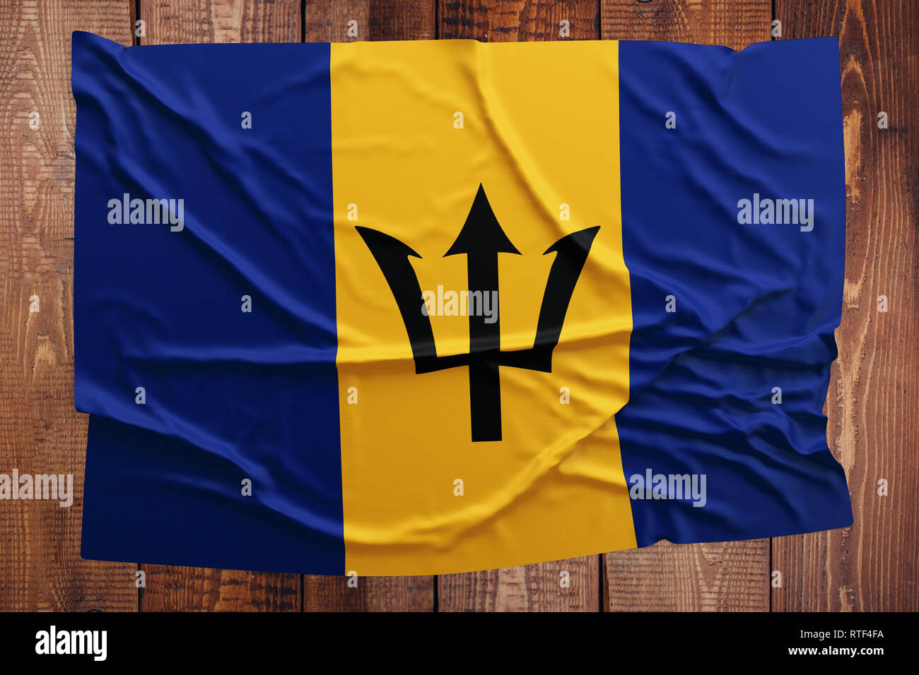 Flag of Barbados on a wooden table background. Wrinkled Barbadian flag ...