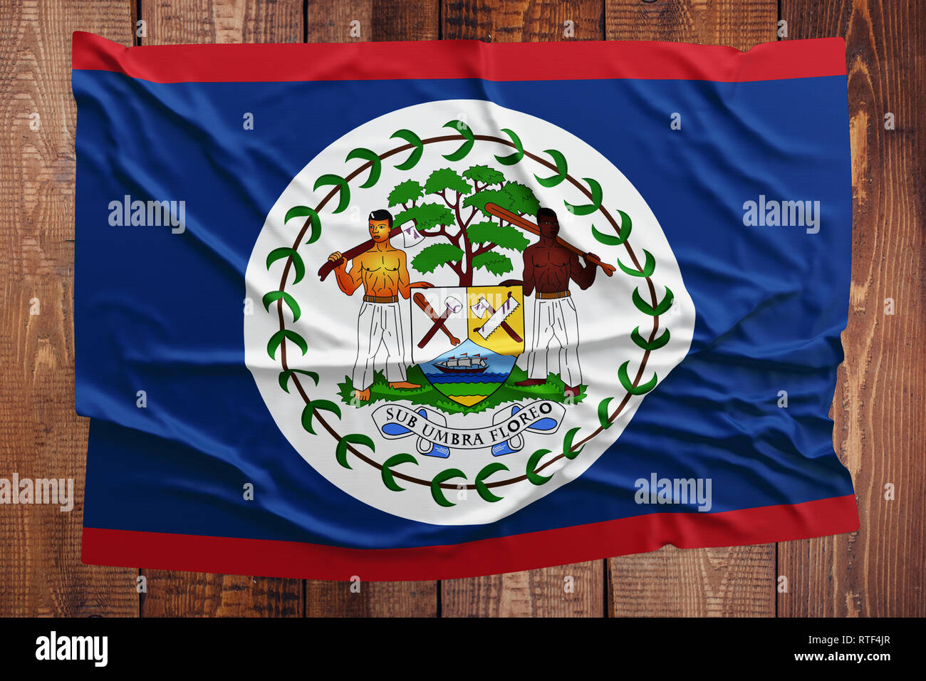 Flag of Belize on a wooden table background. Wrinkled Belizean flag top ...