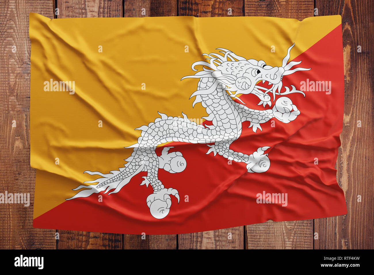 Flag of Bhutan on a wooden table background. Wrinkled Bhutanese flag ...