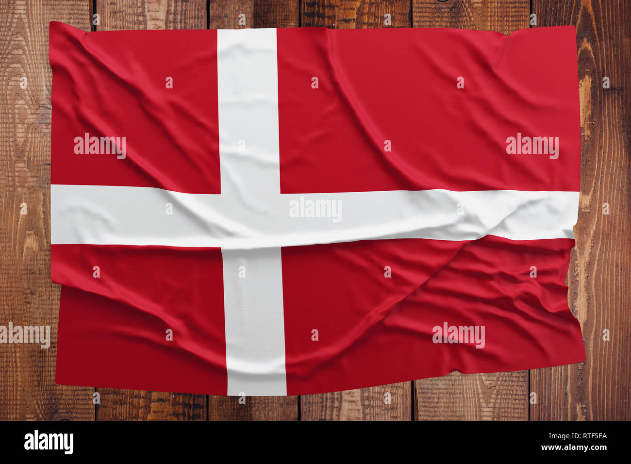 Flag of Denmark on a wooden table background. Wrinkled Danish flag top ...