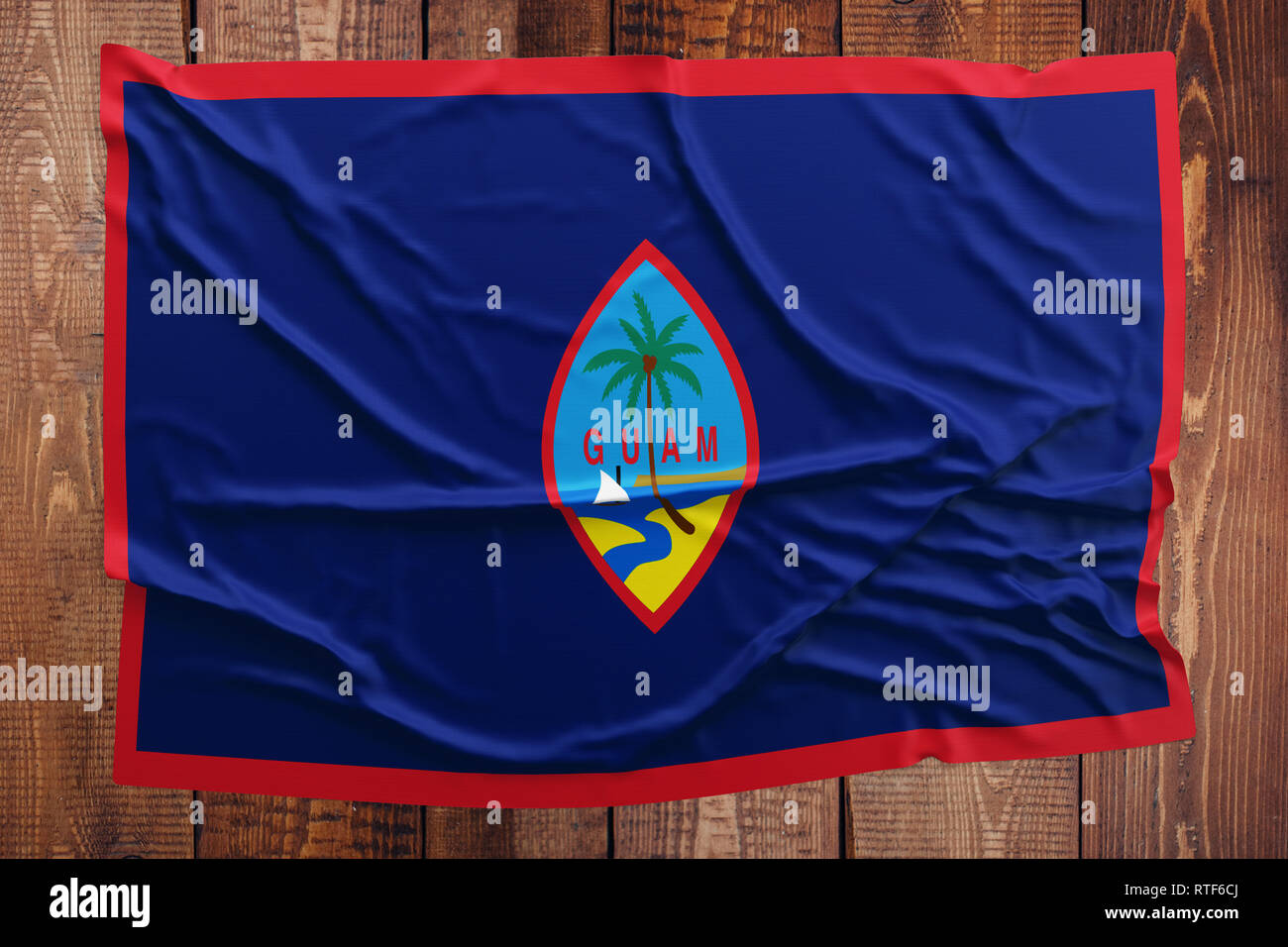 Flag of Guam on a wooden table background. Wrinkled Guahan flag top ...