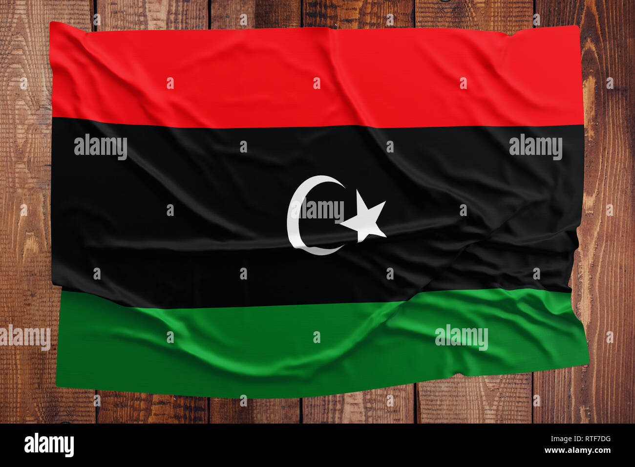 Flag of Libya on a wooden table background. Wrinkled Libyan flag top ...