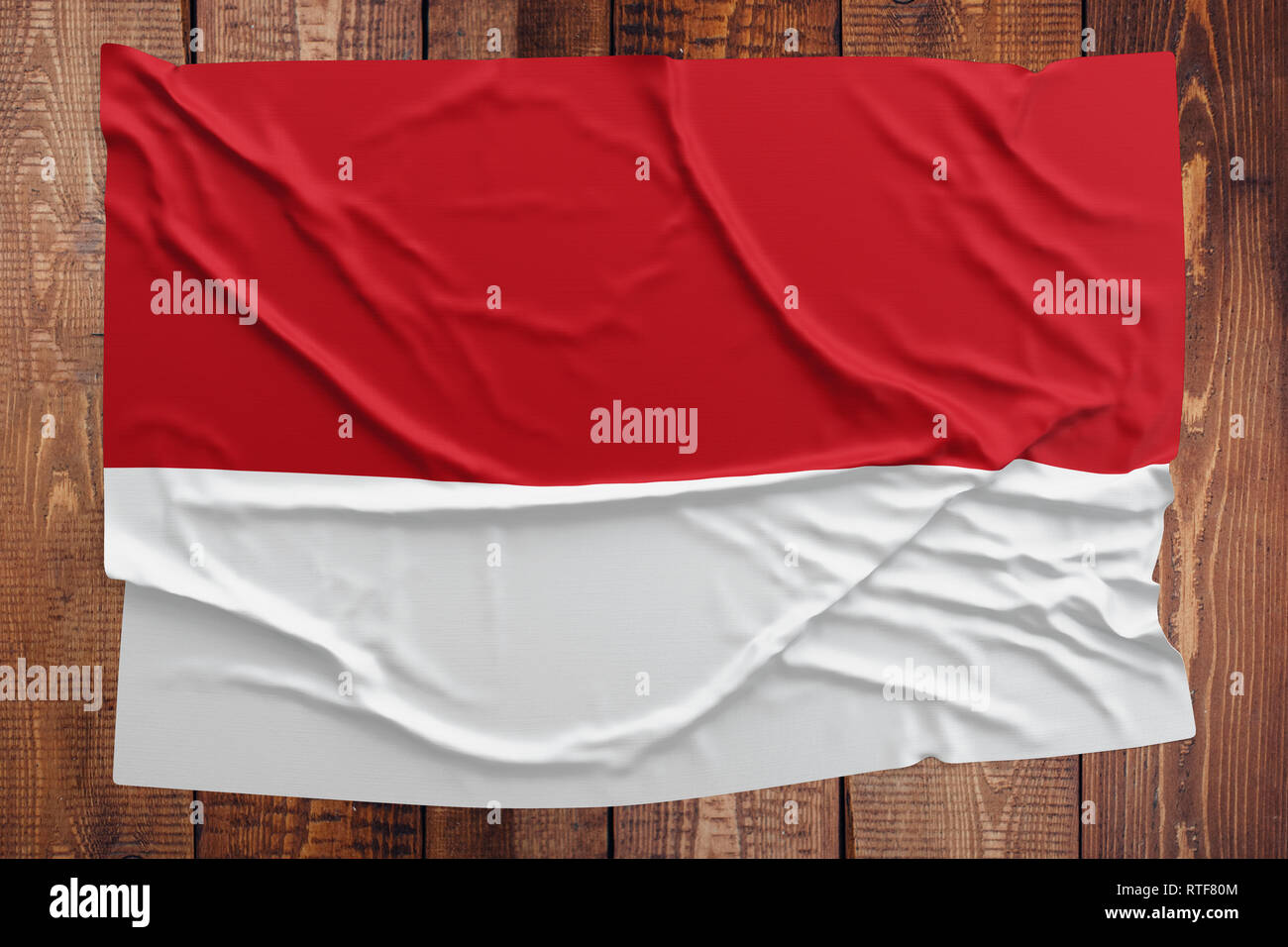 Flag of Monaco on a wooden table background. Wrinkled Monegasque flag ...