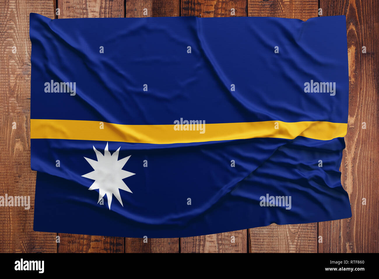 Flag of Nauru on a wooden table background. Wrinkled Nauruan flag top ...