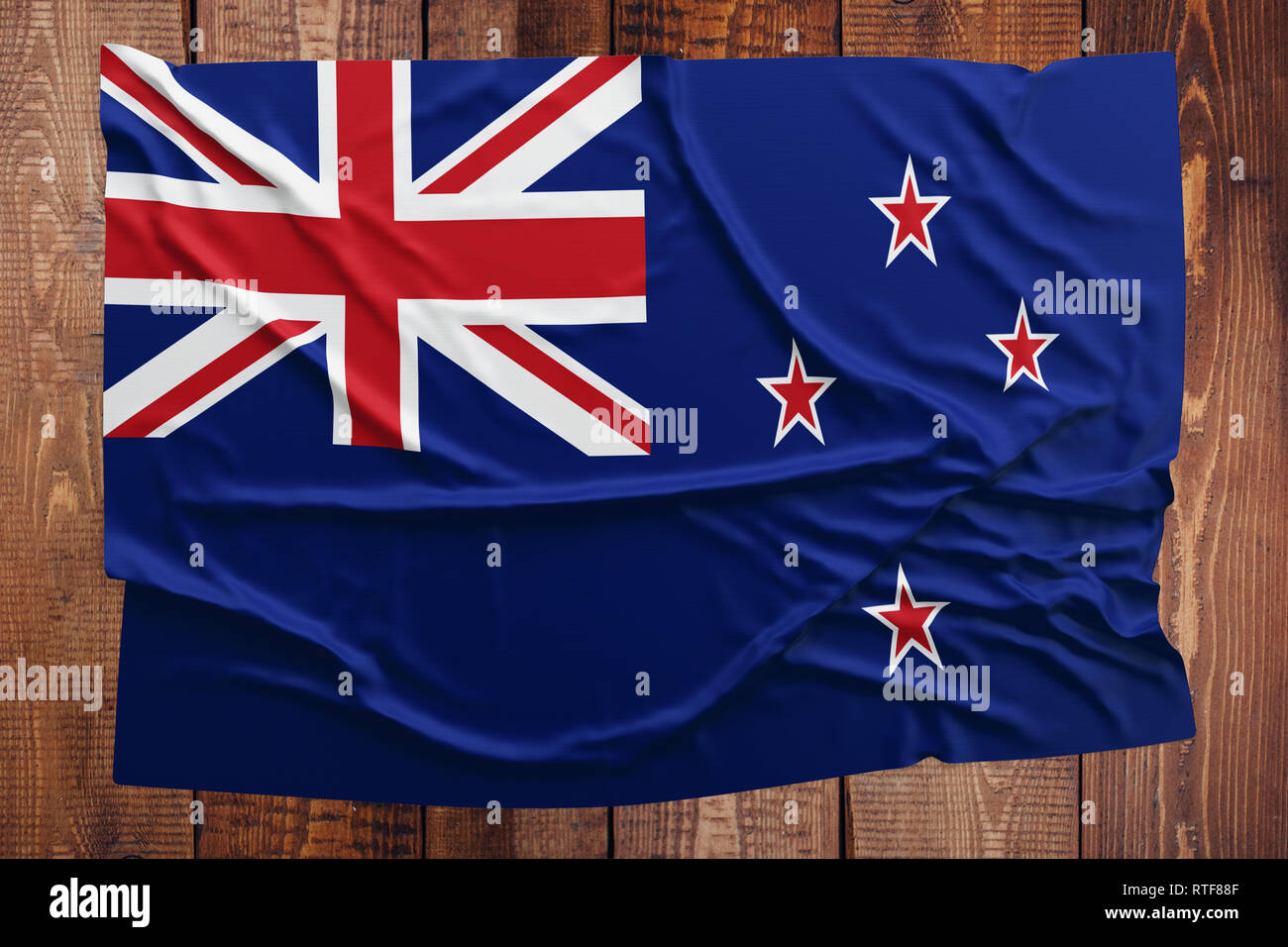 Flag of New Zealand on a wooden table background. Wrinkled Kiwi flag ...