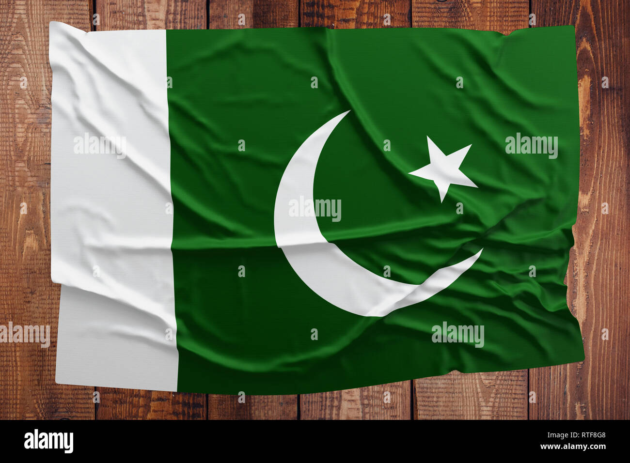 Flag of Pakistan on a wooden table background. Wrinkled Pakistani flag ...