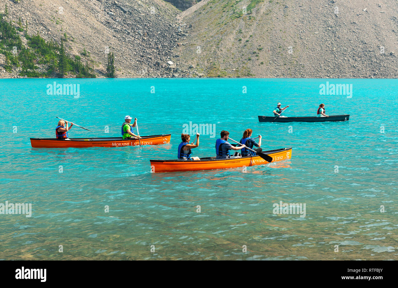 Tourists kayaking on the turquoise glacier waters of Lake Moraine ...