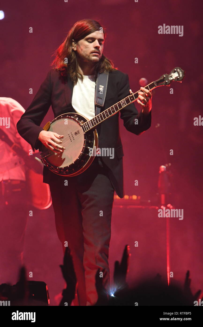 Musician Winston Marshall is shown performing on stage during a "live ...