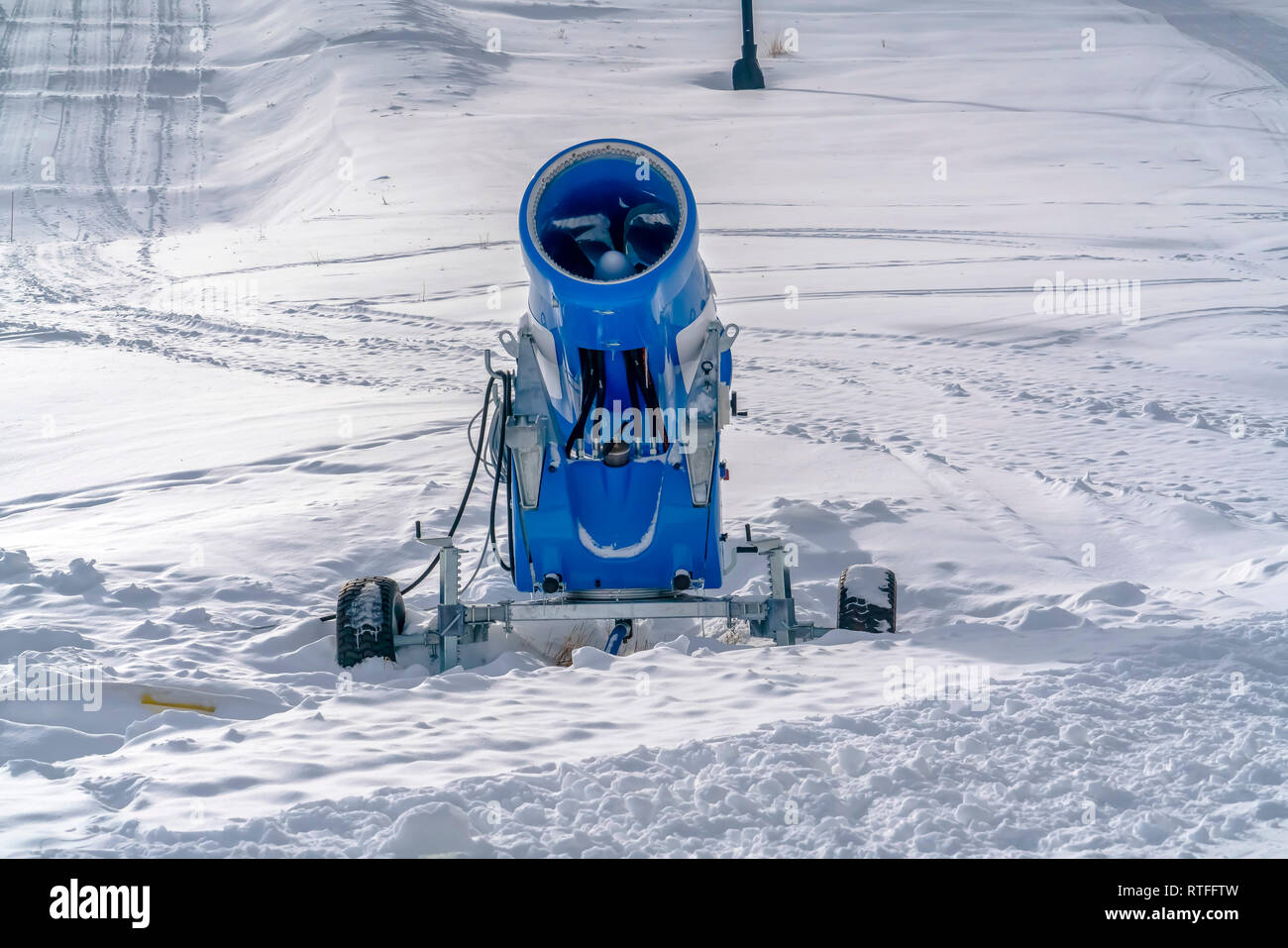 Blue snow cannon on snow covered ground in Utah. The bright blue color ...