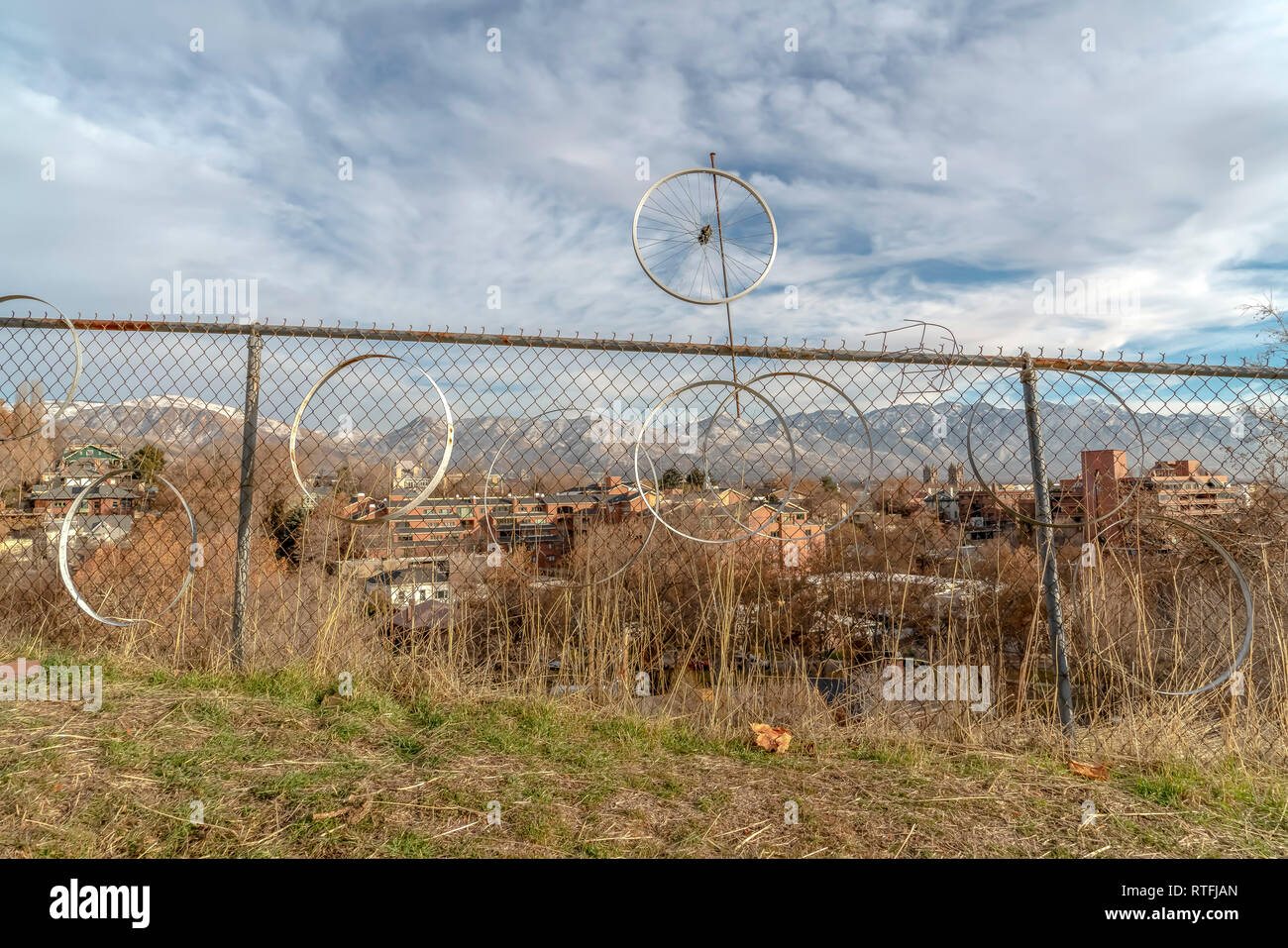 Old bike wheel rims hanging on a rusty metal fence. Old bicycle wheel ...