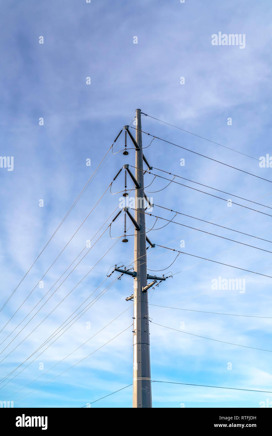 Overhead power line against peaceful cloudy sky. An overhead power line ...