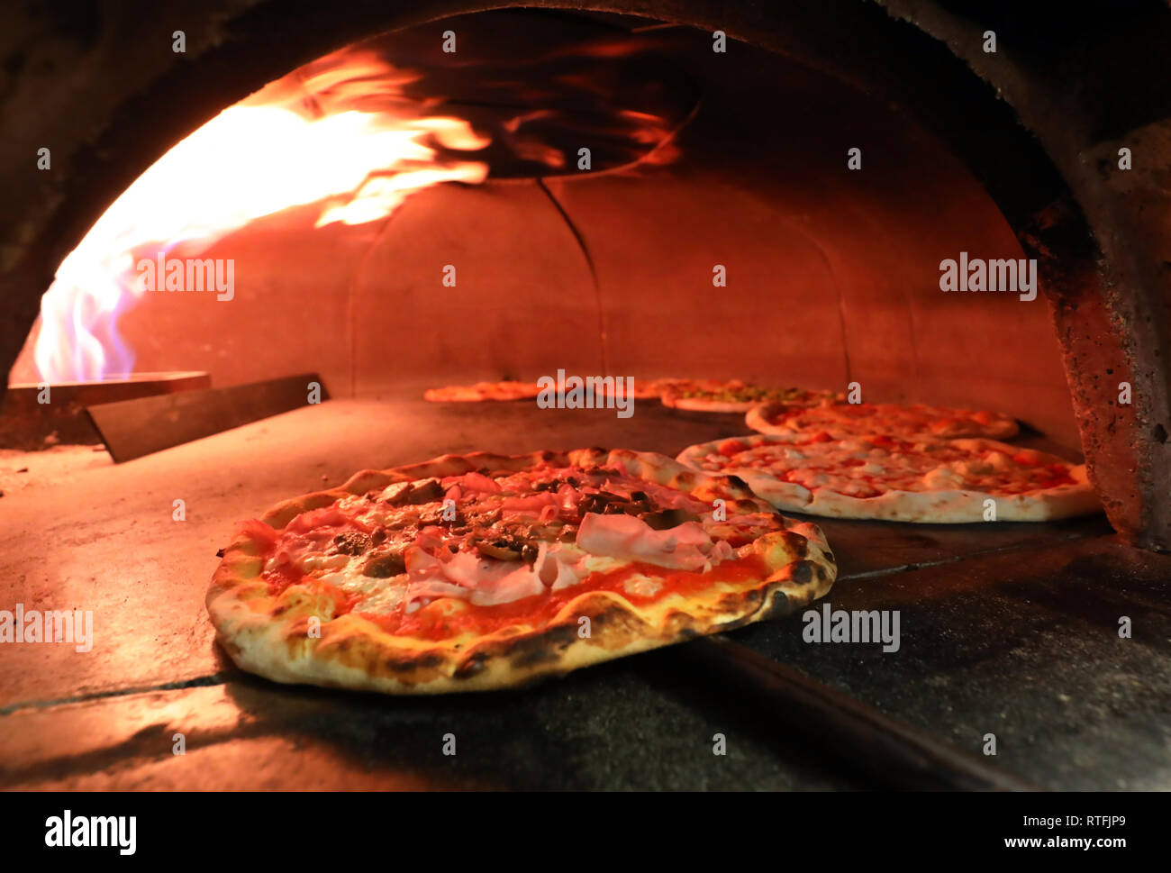 fire inside an oven of Italian pizzeria with pizzas cooking Stock Photo ...