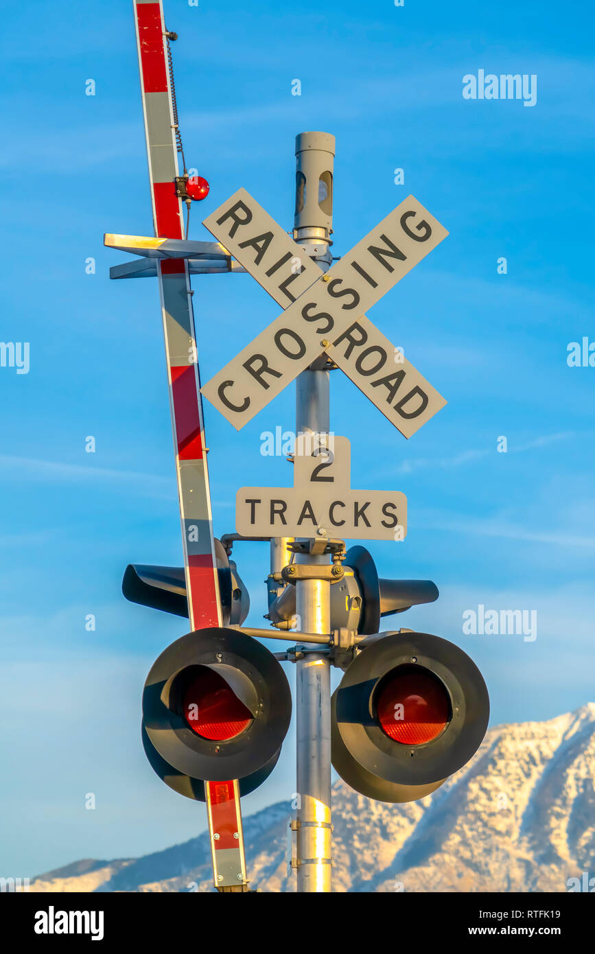 Railroad crossing sign with barrier and red lights. A two tracks ...