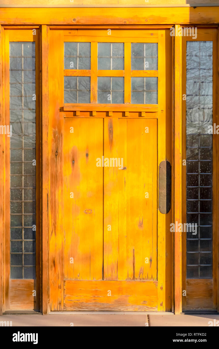 Rustic wooden door with reflective glass panels. Close up view of the ...