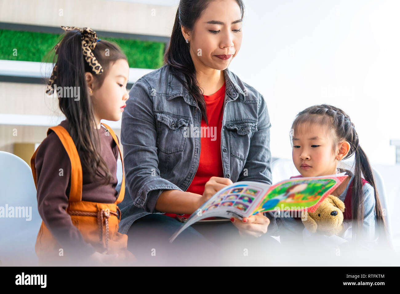 Teacher is reading story book to kindergarten students Stock Photo - Alamy