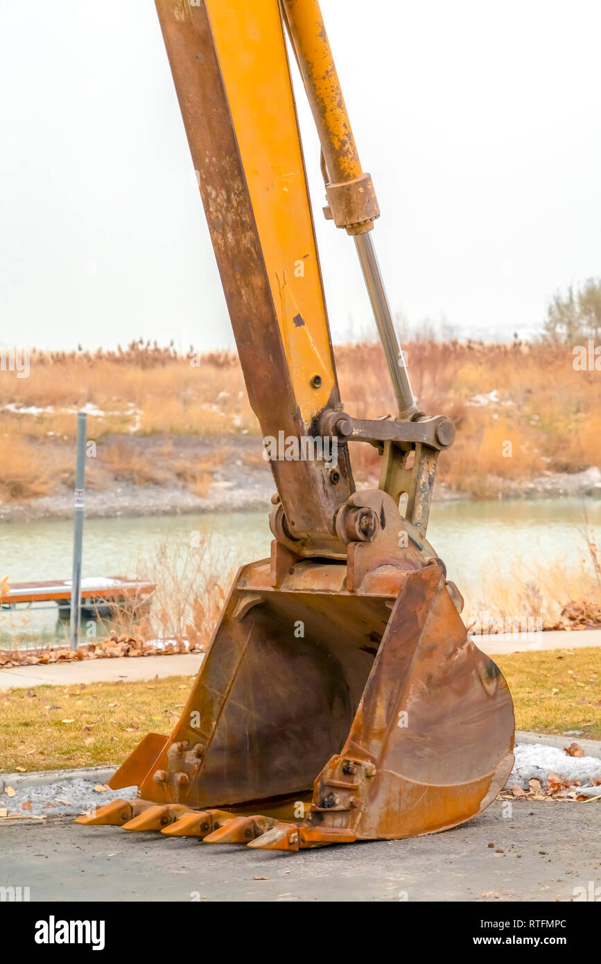 The dirty dipper and bucket of a yellow excavator. Close up view of the ...