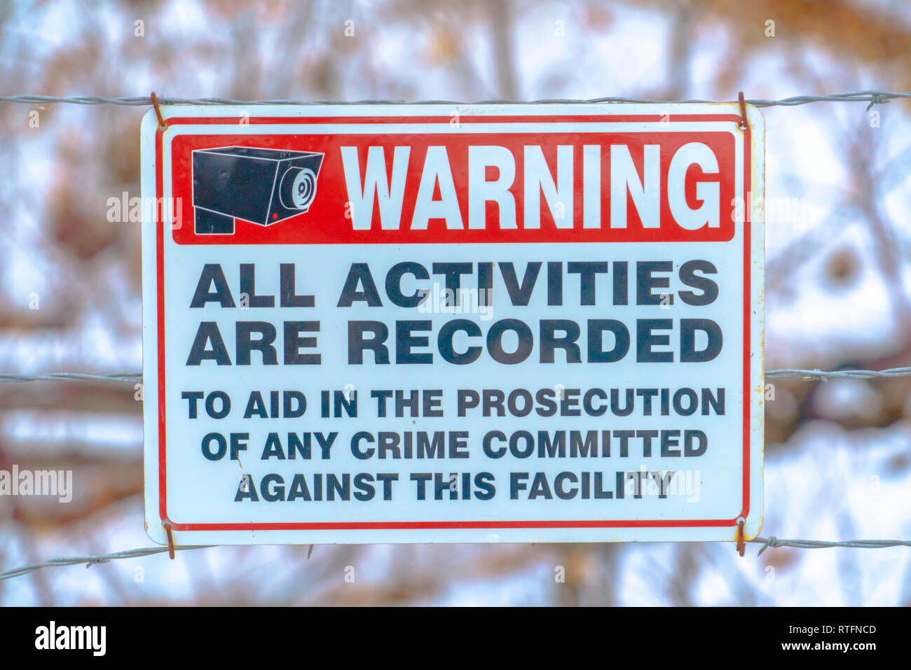 Warning sign on a barbed wire fence. Close up view of a Warning sign ...