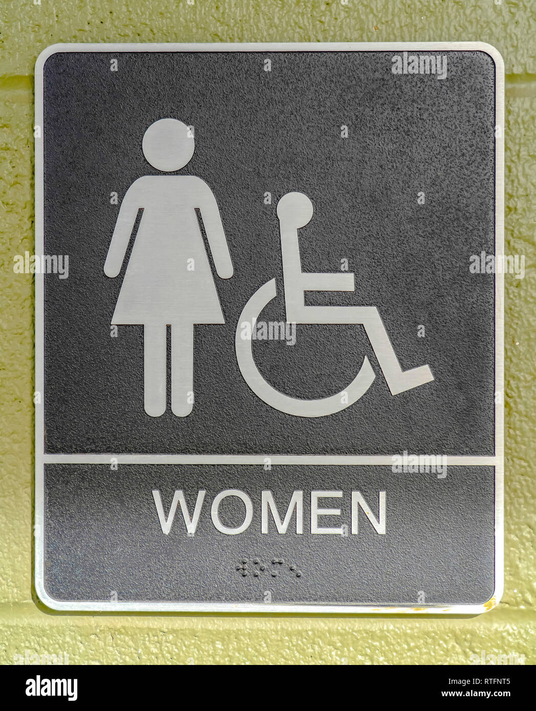 Women restroom sign posted on a green wall. Close up view of a restroom ...