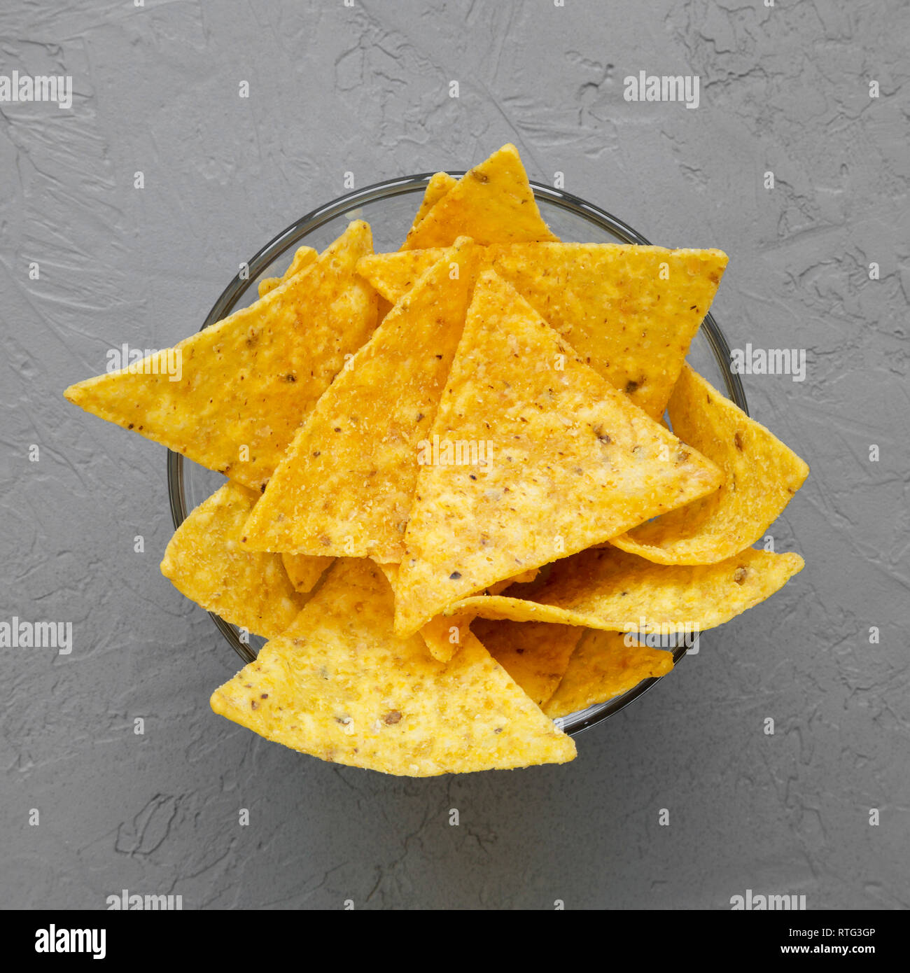 Top view, full bowl of tortilla chips on concrete background. Mexican ...