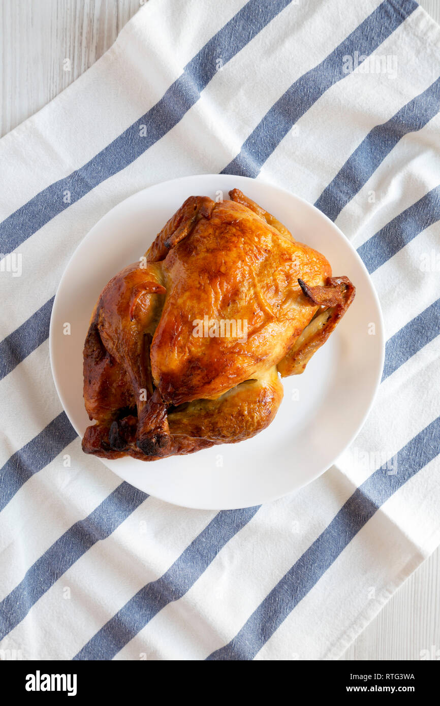 Homemade traditional rotisserie chicken on white plate, top view. Flat ...