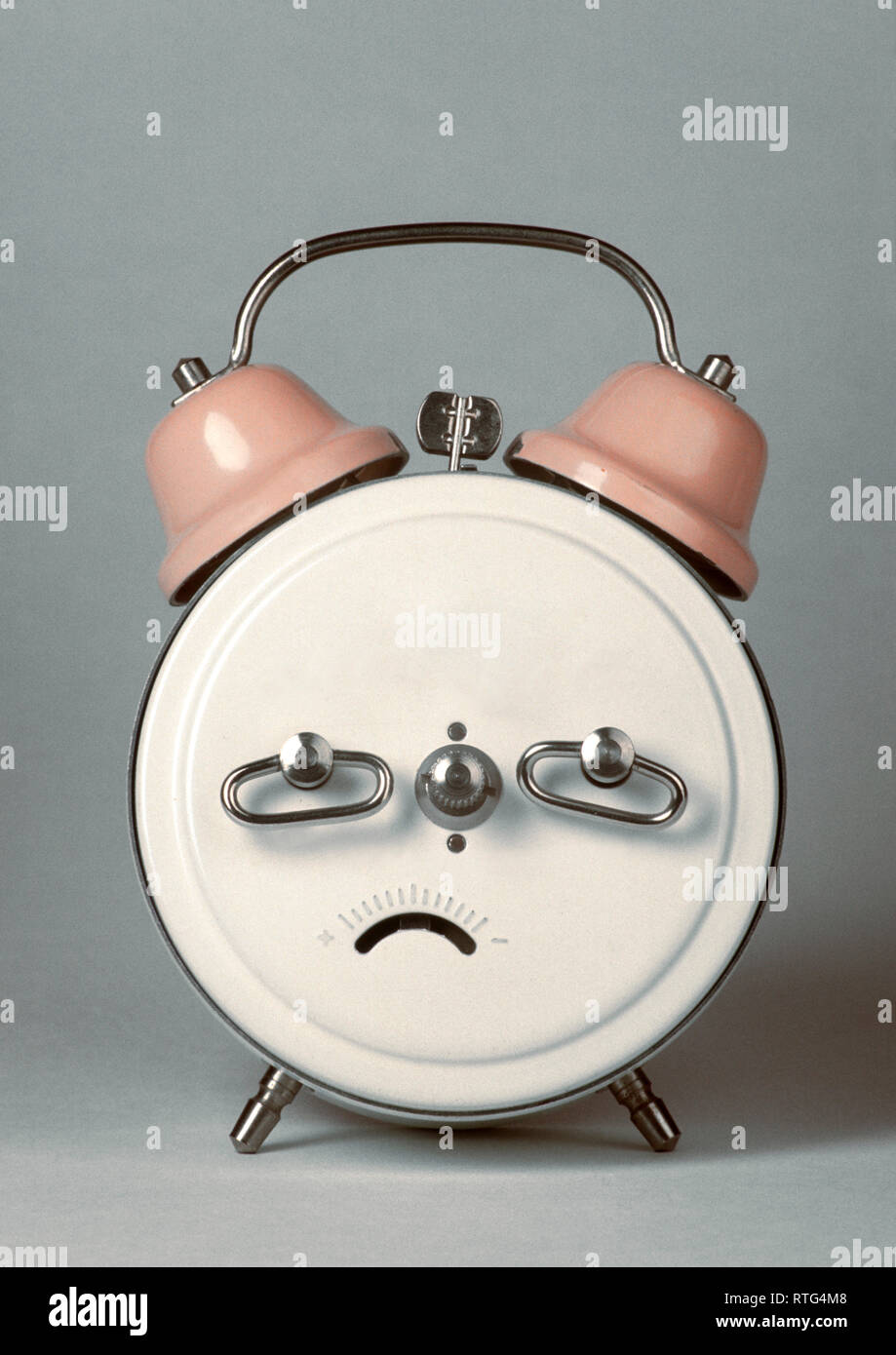 Back of an alarm clock in the shape of a frowning face Stock Photo - Alamy