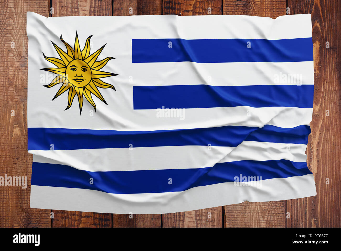 Flag of Uruguay on a wooden table background. Wrinkled Uruguayan flag ...