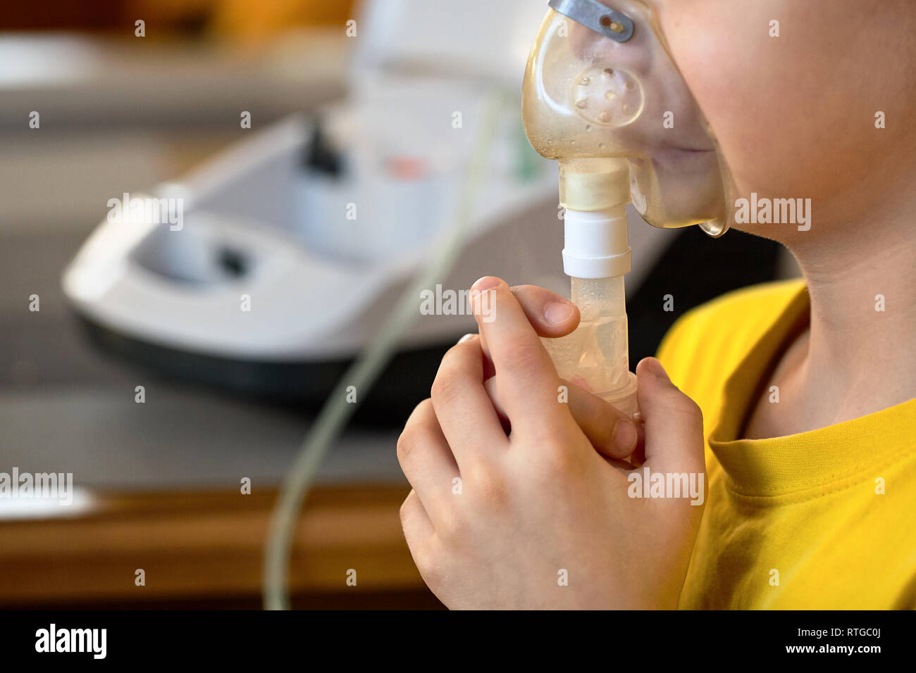 Сhild makes inhalation at home with nebulizer on out of focus ...