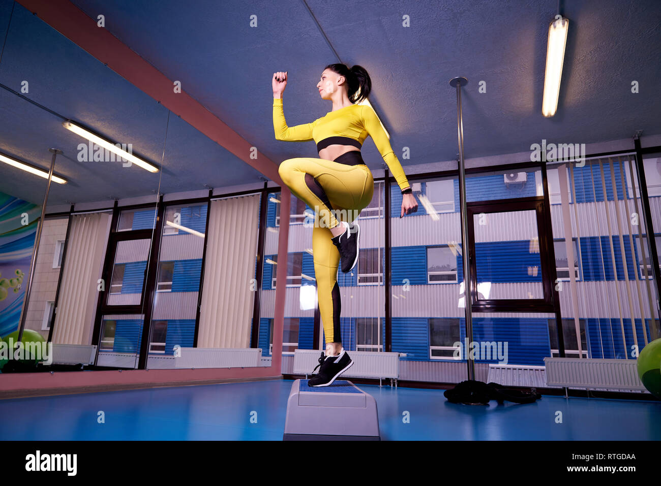 Athletic young woman using step platform in the gym Stock Photo - Alamy