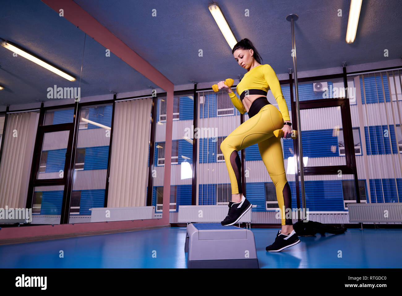 Athletic young woman using step platform in the gym Stock Photo - Alamy