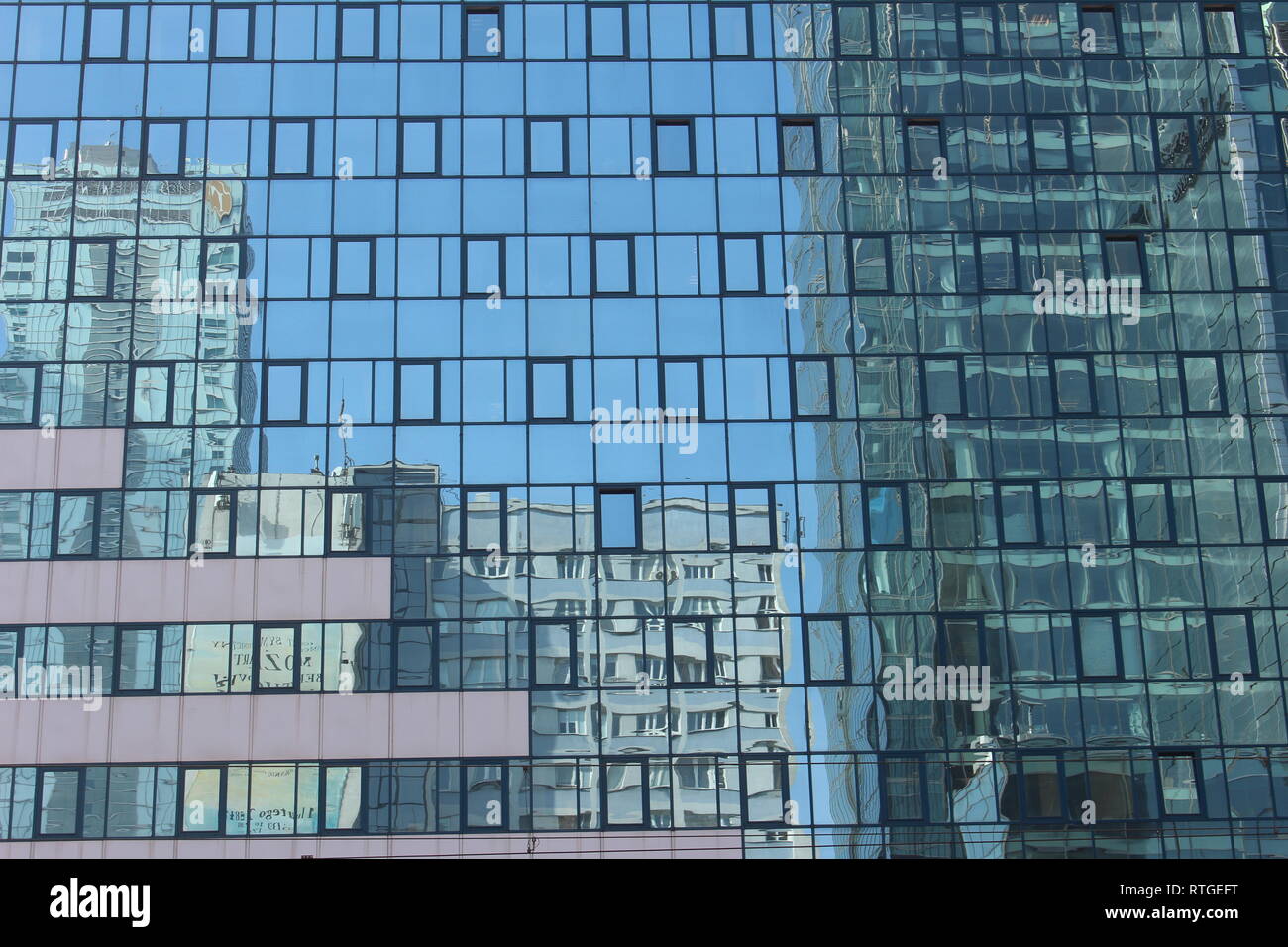 Warsaw, reflection of block towers in the windows of a modern building ...