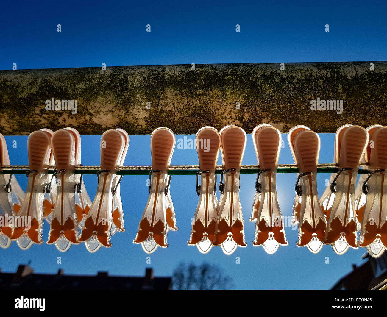 Close up of pegs for clothes on a line in front of the clear blue sky ...