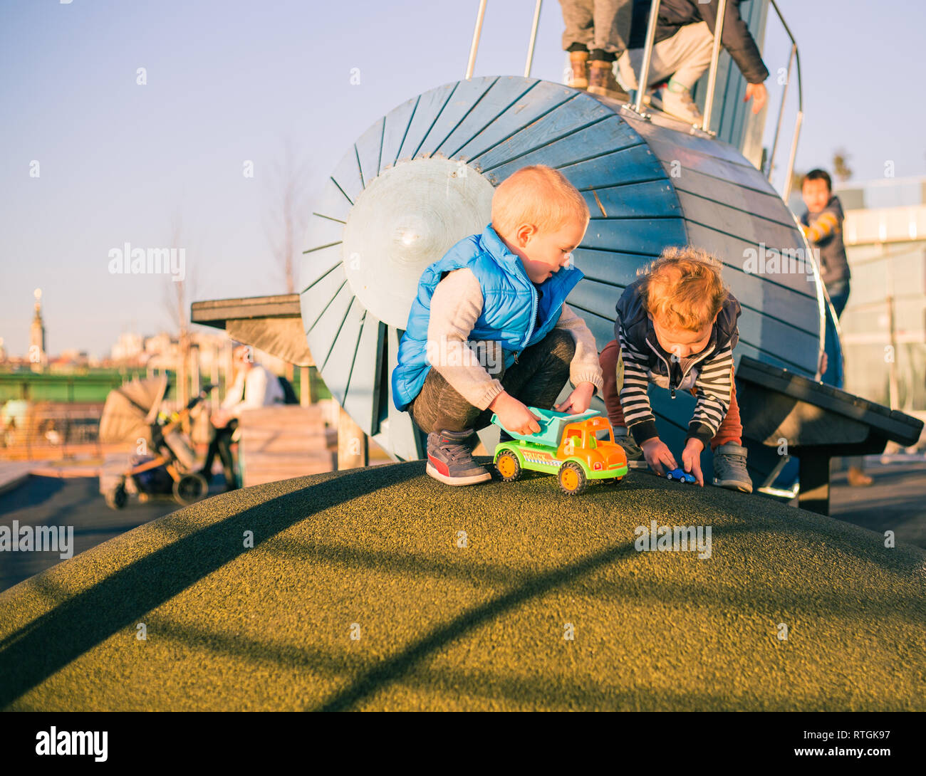 Two little boys playing outside with toys Stock Photo - Alamy