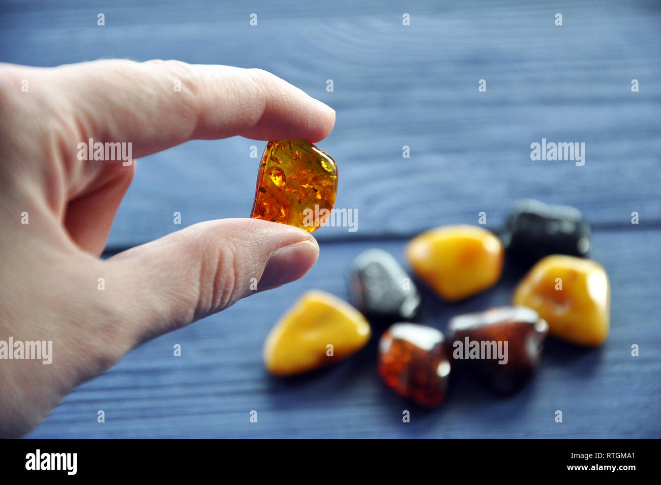 Selective focus of the little amber stone with inclusions in the hand ...