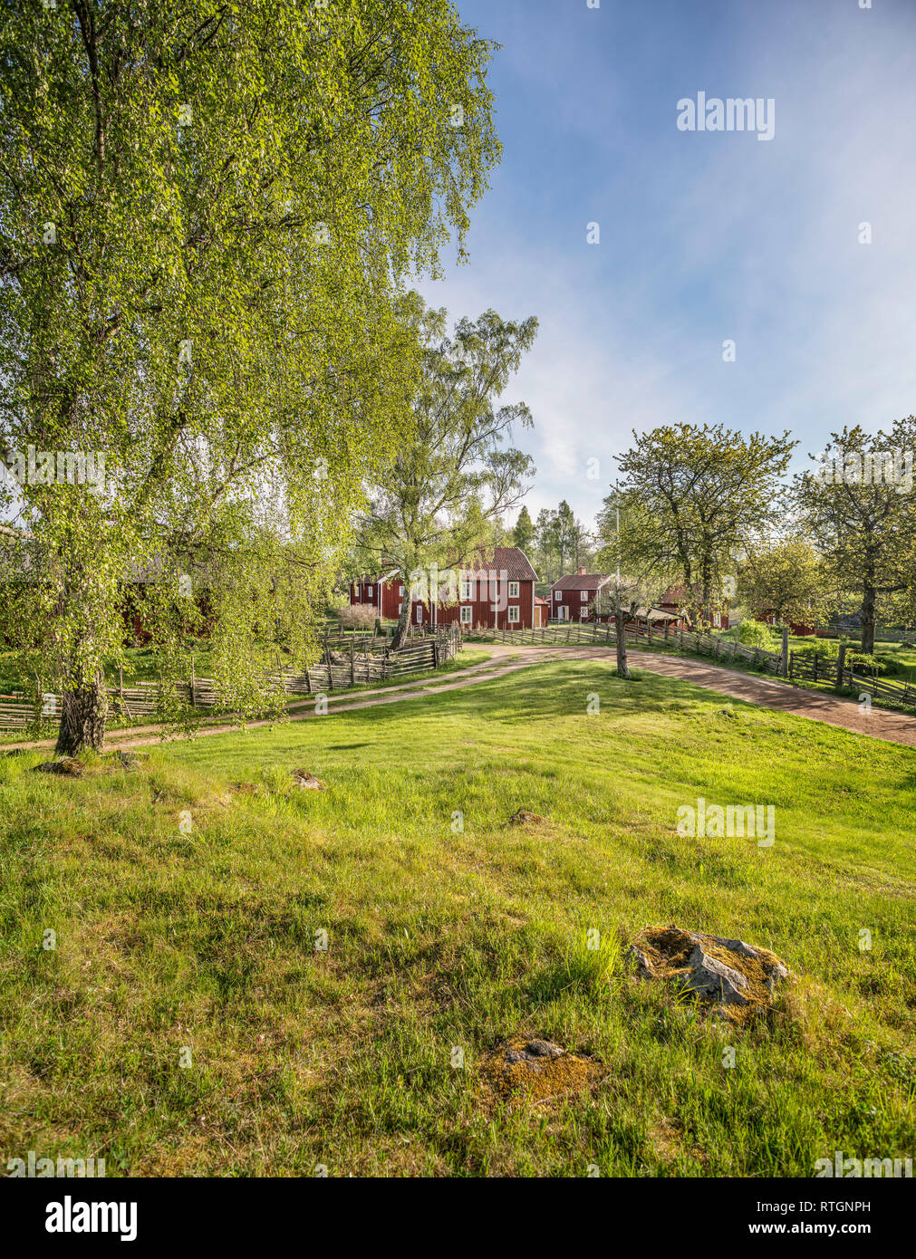 Small road and old cottages by traditional roundpole fence in a rural ...
