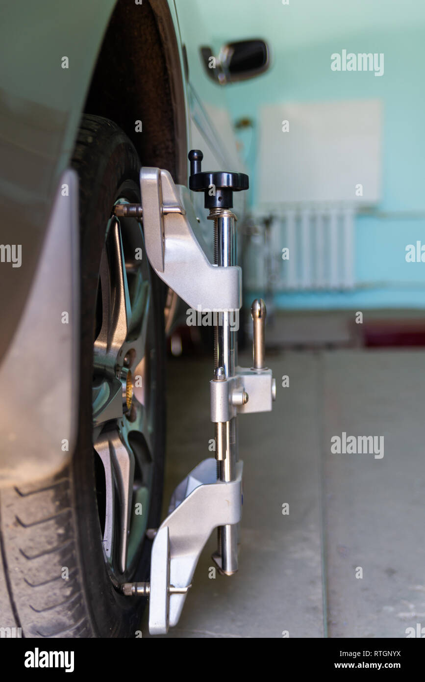Car on stand with sensors on wheels for wheels alignment camber check ...