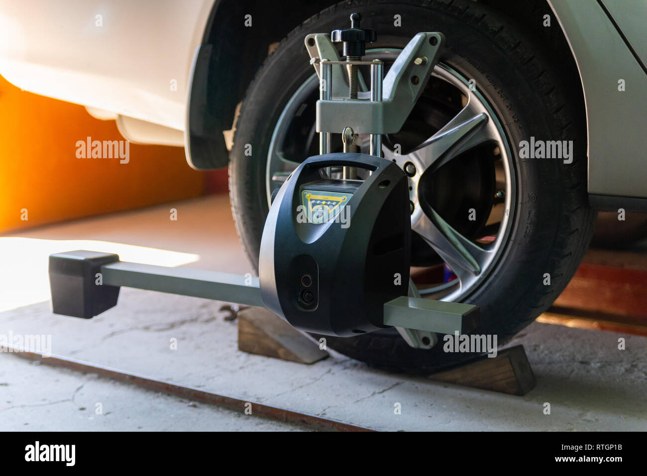 Car on stand with sensors on wheels for wheels alignment camber check ...