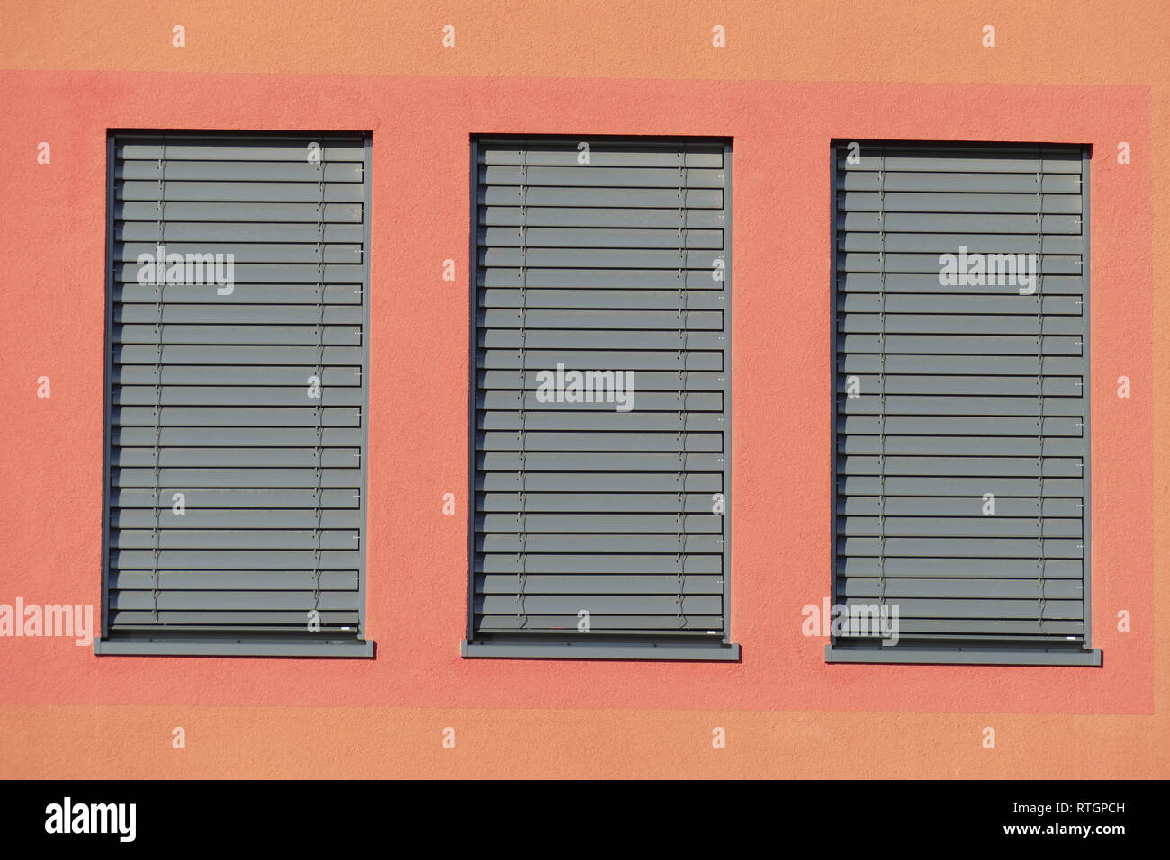 Window with dark shuttered blinds on a red house wall Stock Photo - Alamy