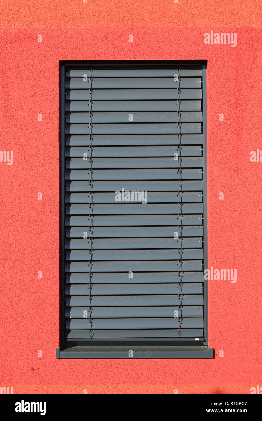 Window with dark shuttered blinds on a red house wall Stock Photo - Alamy