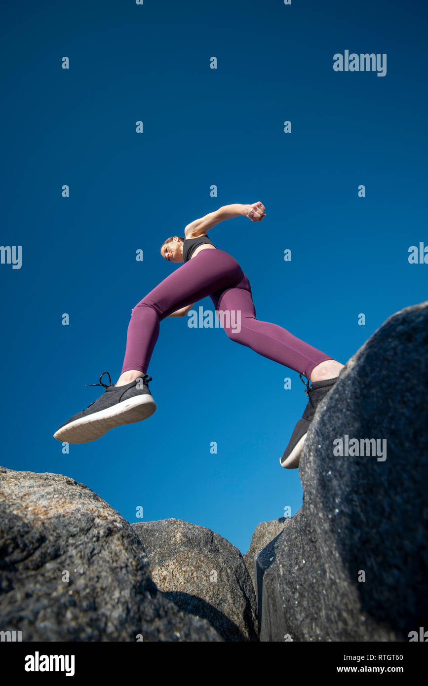 woman running across rocks, cross country, fitness Stock Photo - Alamy