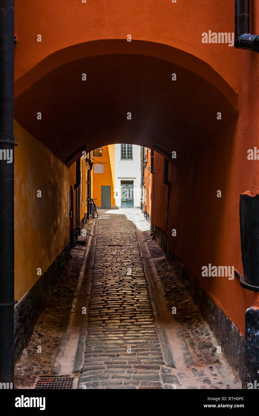 Long medieval orange archway under the building leading to inside yard ...