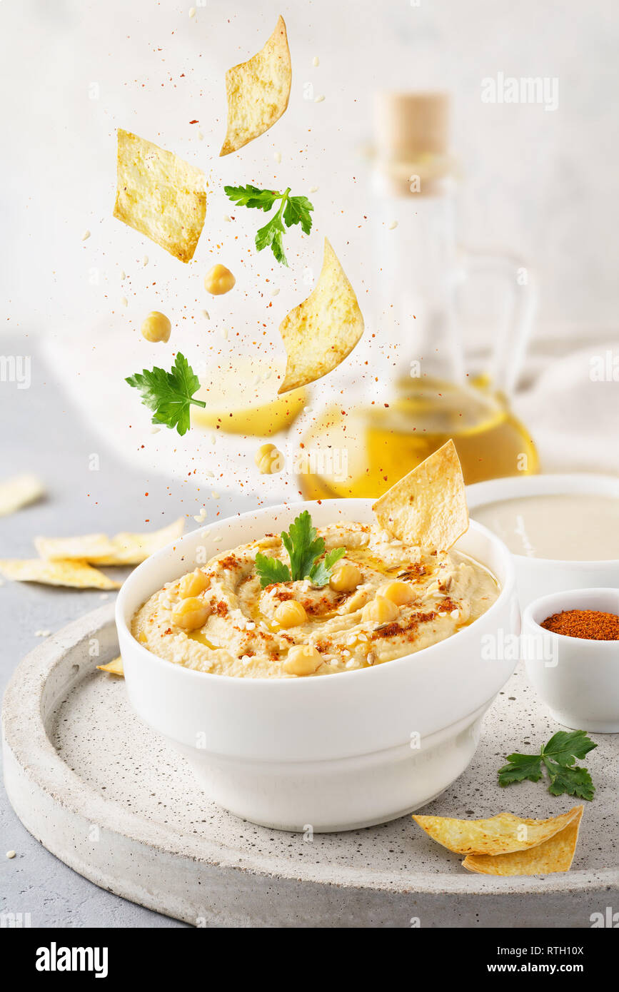 Hummus bowl and falling ingredients - chickpeas, parsley, paprika and ...