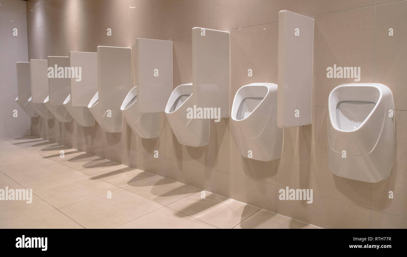 Row of modern Urinals in new bathroom of Theater Stock Photo - Alamy