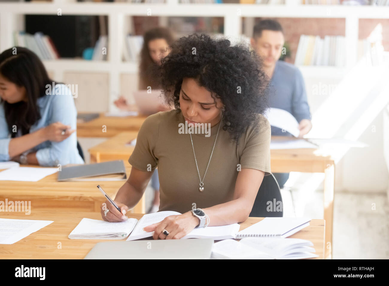 Focused african female college high school student studying in ...