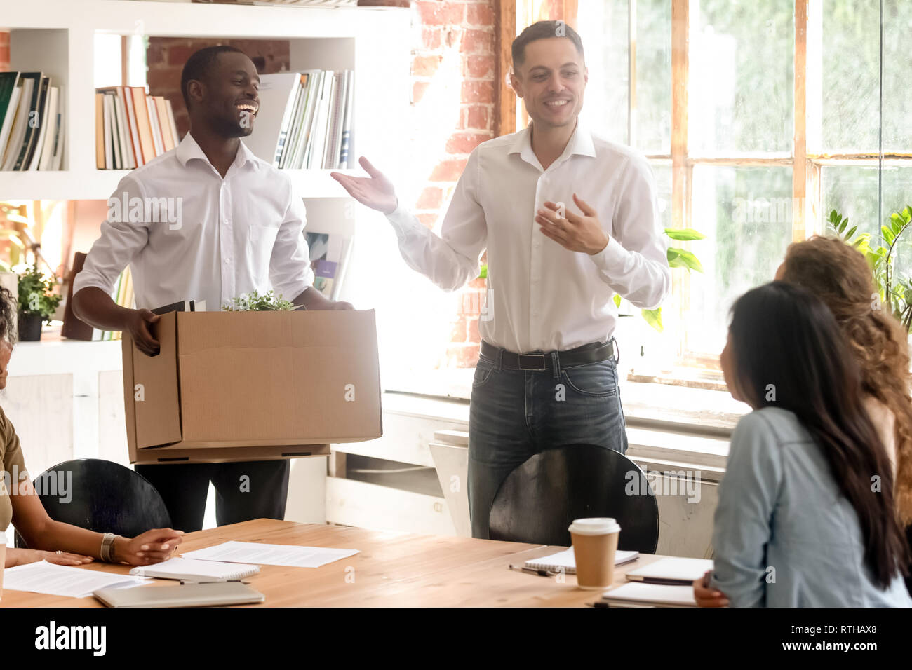 Friendly manager and company staff welcoming happy new african worker ...