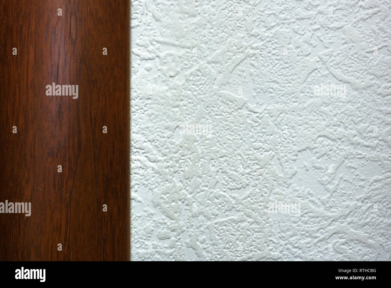 Wooden door trim on the background of texture wallpaper close-up with ...