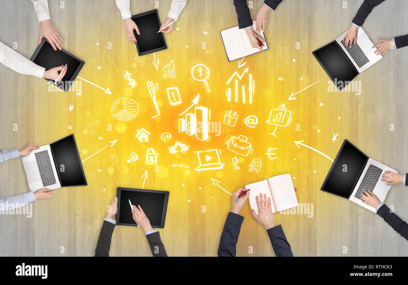 Group of people with devices in hands making reports together on laptop ...