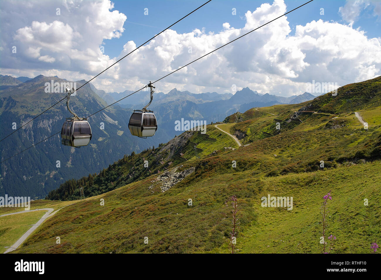 Aerial cable car view hanging over green Austrian Alps in summer with ...