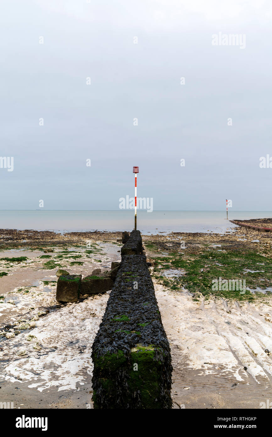 Concrete wave breaker with navigation pole at end, jutting out on the ...