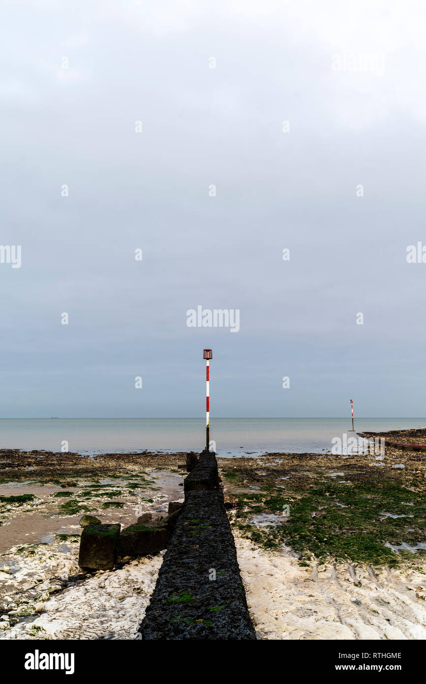 Concrete wave breaker with navigation pole at end, jutting out on the ...
