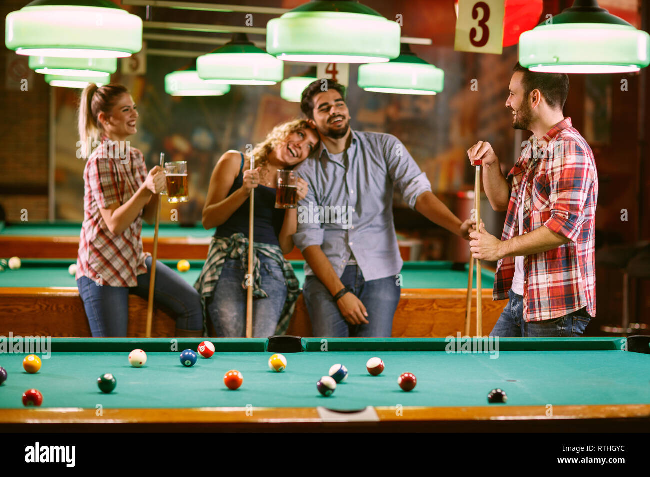Group of friends having fun while playing billiard in bar Stock Photo ...